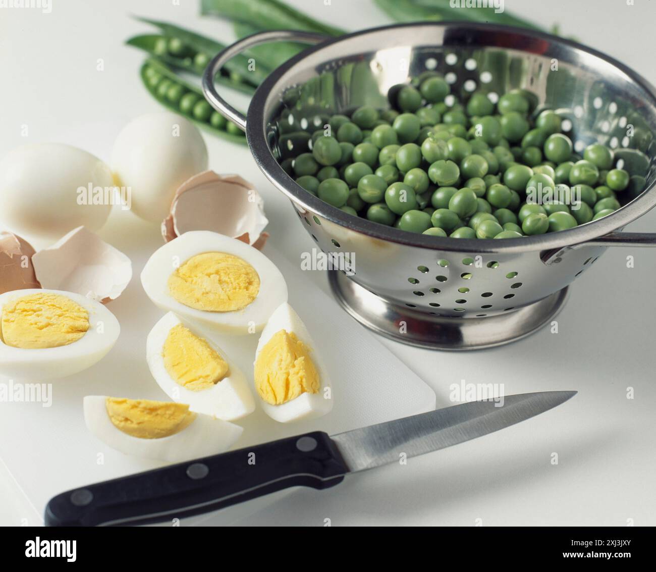Cutting the hard-boiled eggs and strain the peas Stock Photo - Alamy