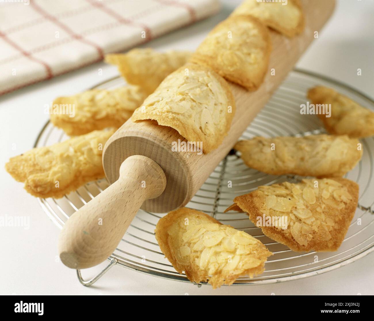 Shaping the tuile biscuits on rolling pin Stock Photo - Alamy
