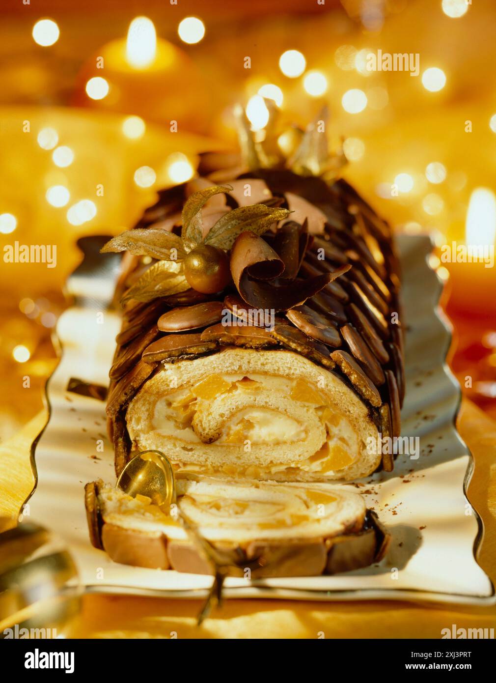 Crunchy chocolate-coated, orange and peach Yule log Stock Photo - Alamy