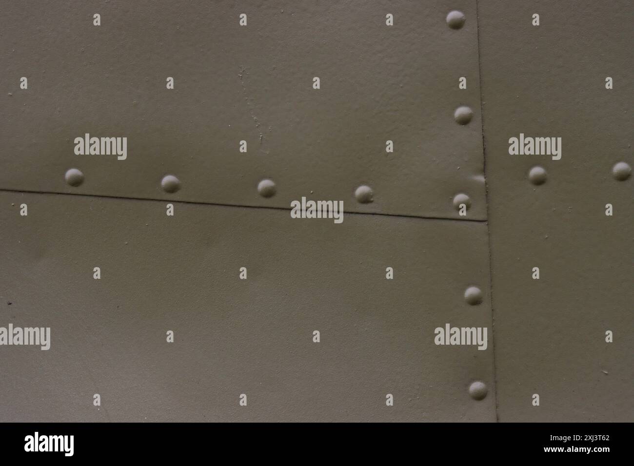 The surface of a metal wall with green rivets. Airplane fuselage ...