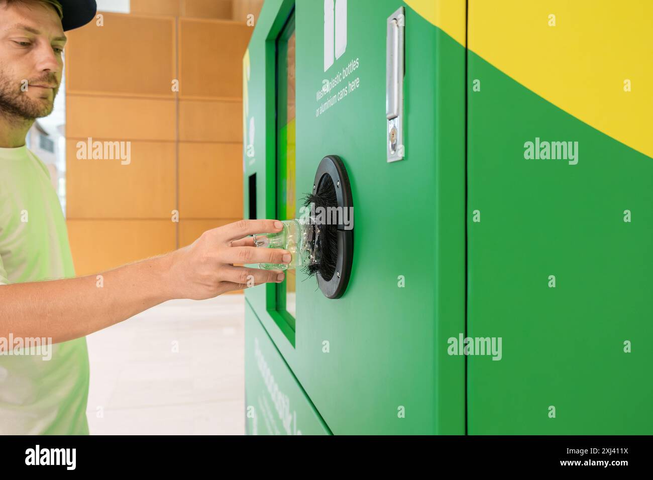 Man puts plastic bottle in a reverse vending machine. Male inserting ...