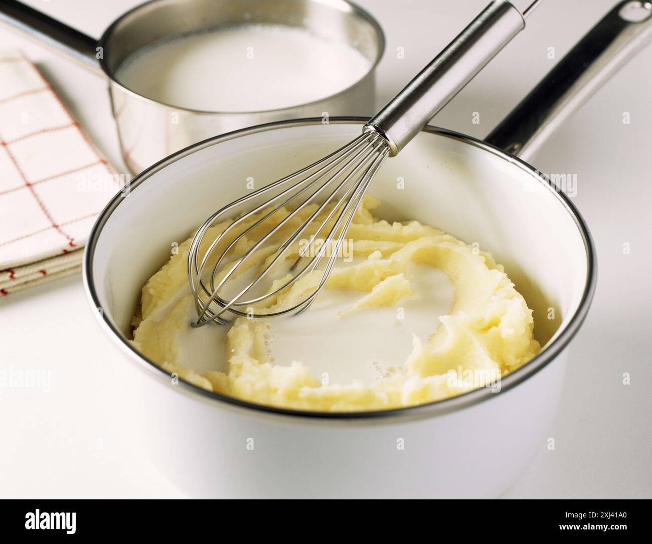 Slowly adding the milk while mixing Stock Photo - Alamy
