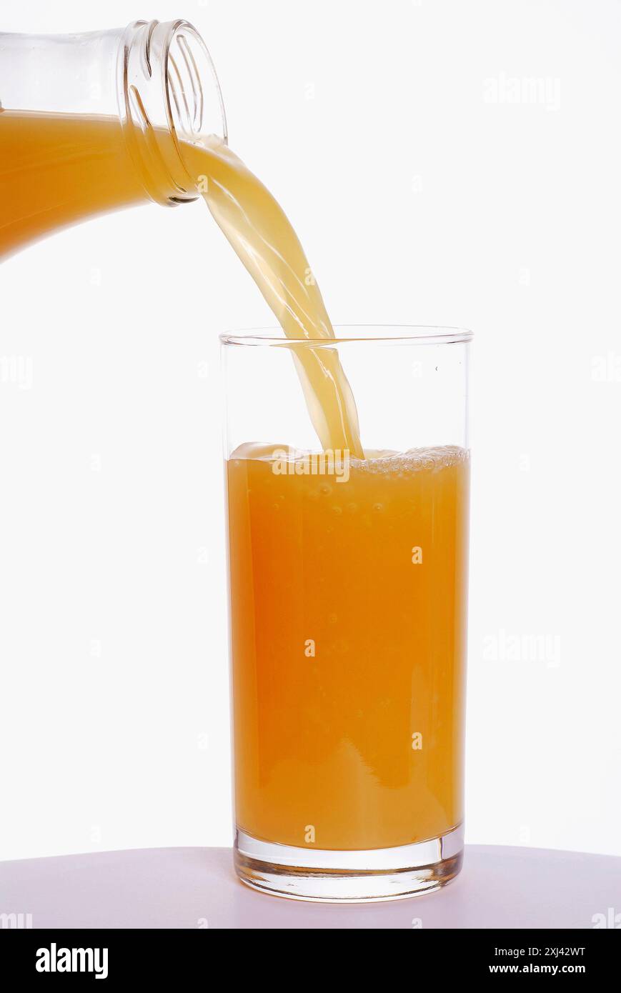 Pouring apple juice into a glass Stock Photo - Alamy