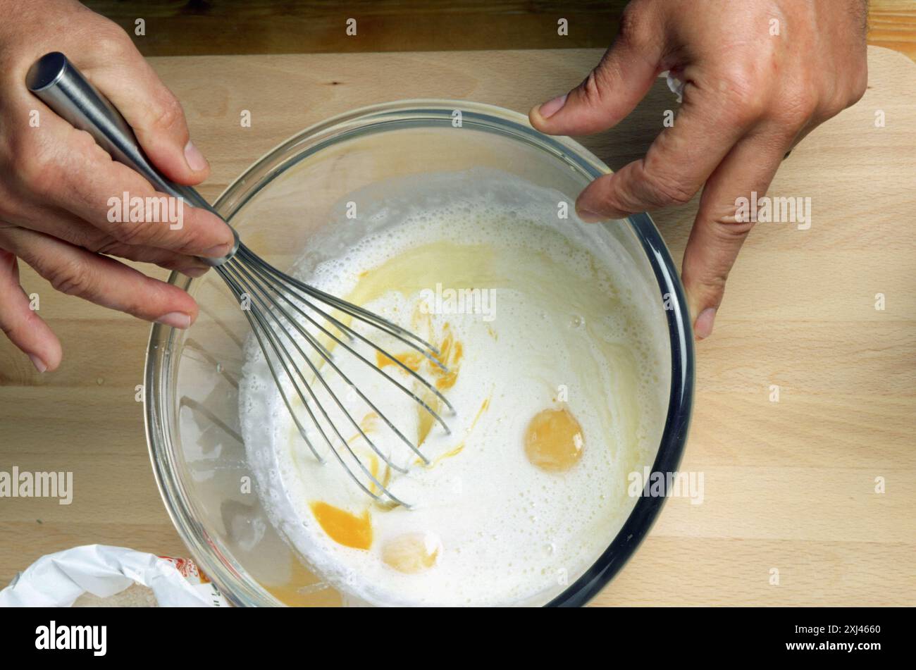 Adding the eggs and mixing together Stock Photo - Alamy