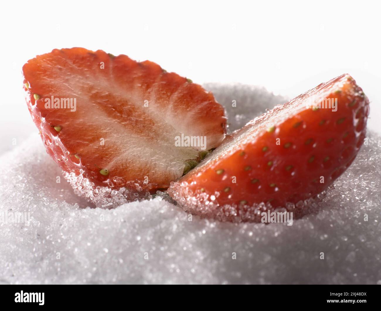 Strawberry cut in half on a heap of sugar Stock Photo - Alamy