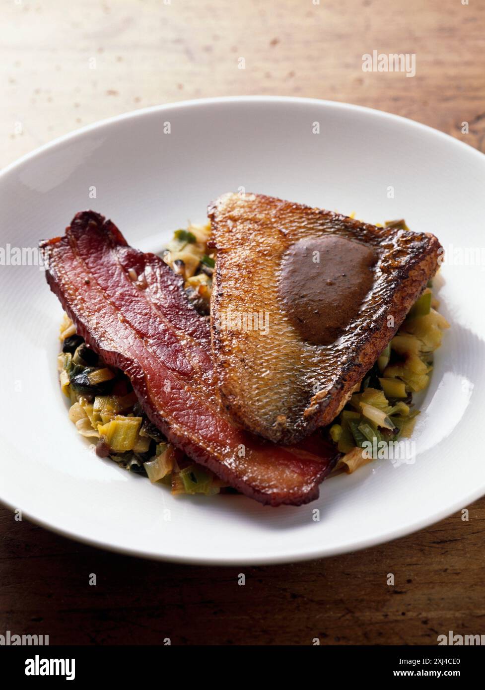 Pan-fried pike-perch with leeks and bacon Stock Photo - Alamy