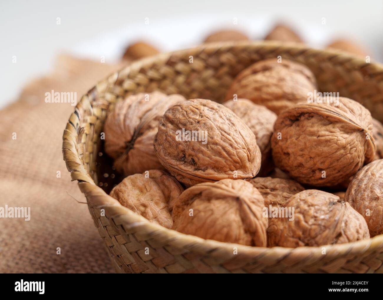 Whole walnuts in wooden rattan bowl, their shells showing intricate ...