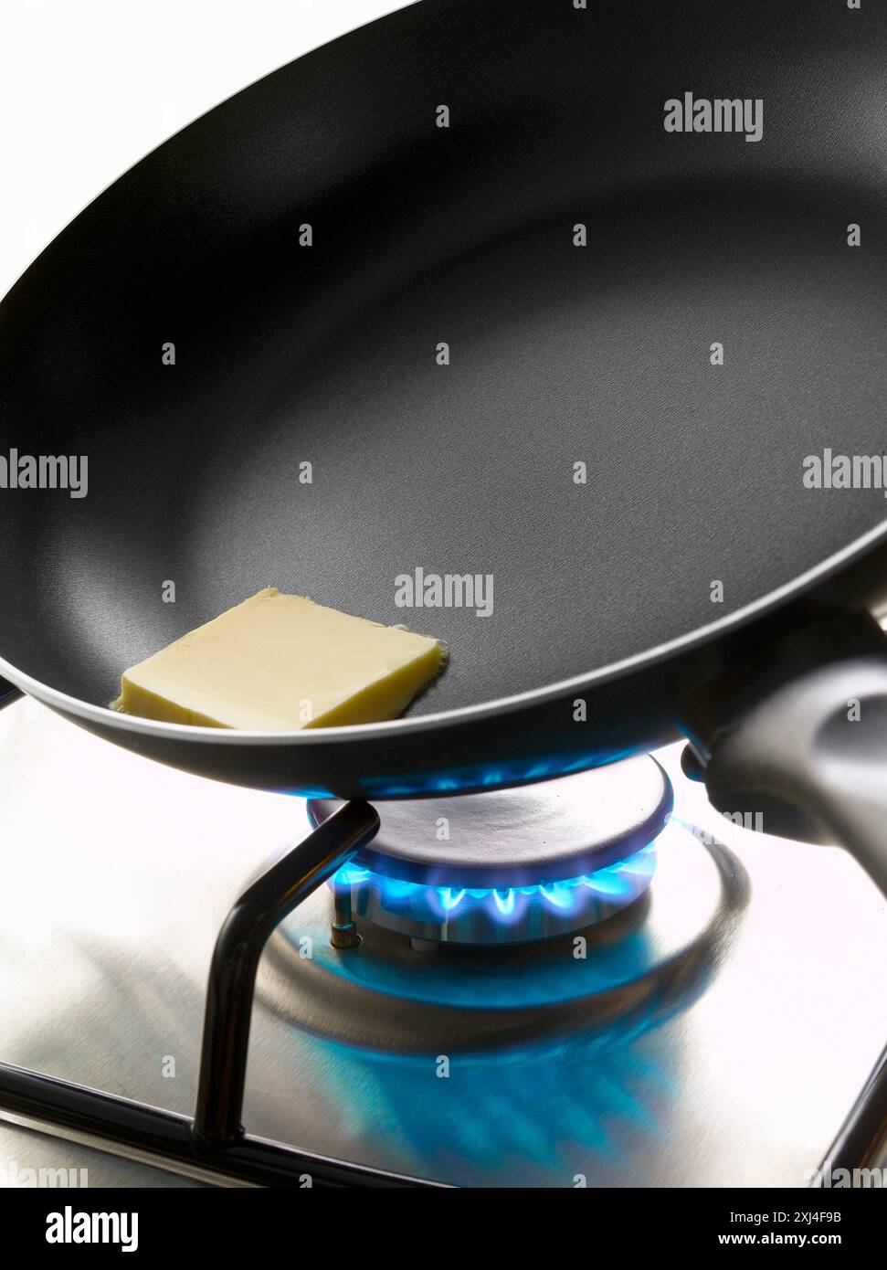 Piece of butter in a frying pan on a gas cooker Stock Photo - Alamy
