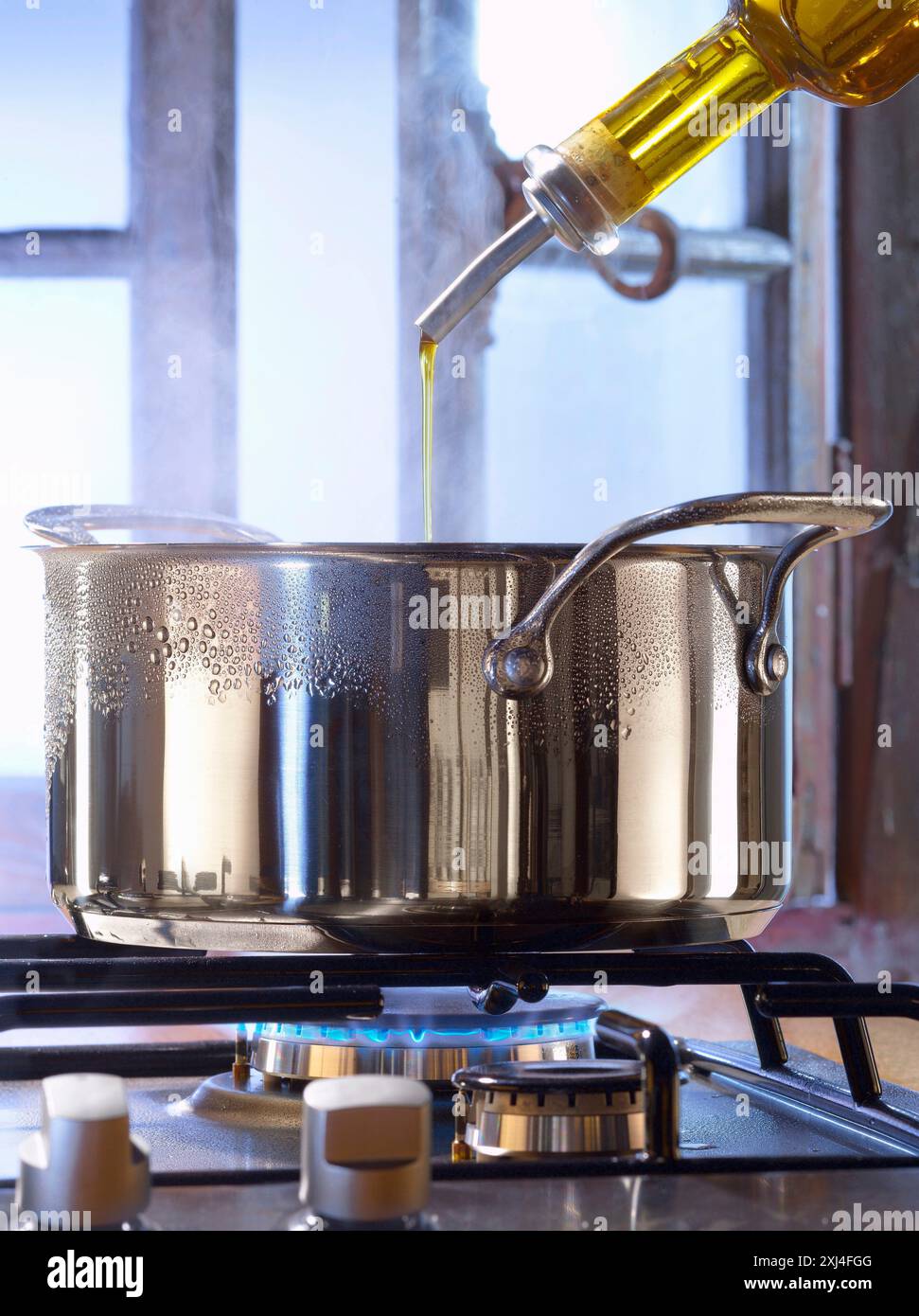 Adding some oil to the boiling water in the saucepan Stock Photo - Alamy