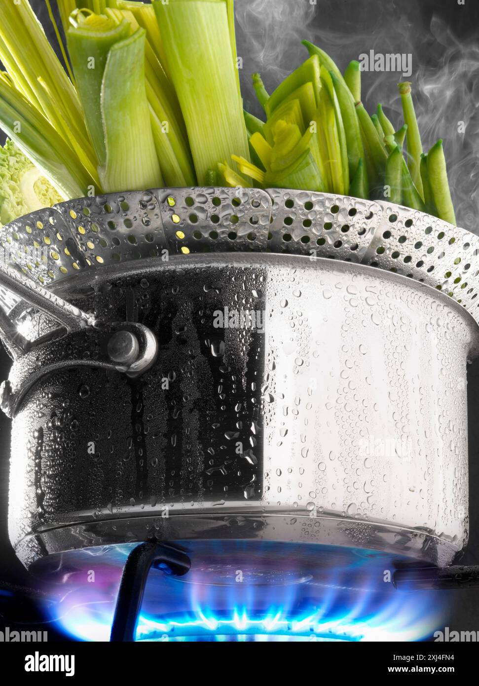 Steam cooking leeks in a saucepan on a gas cooker Stock Photo - Alamy