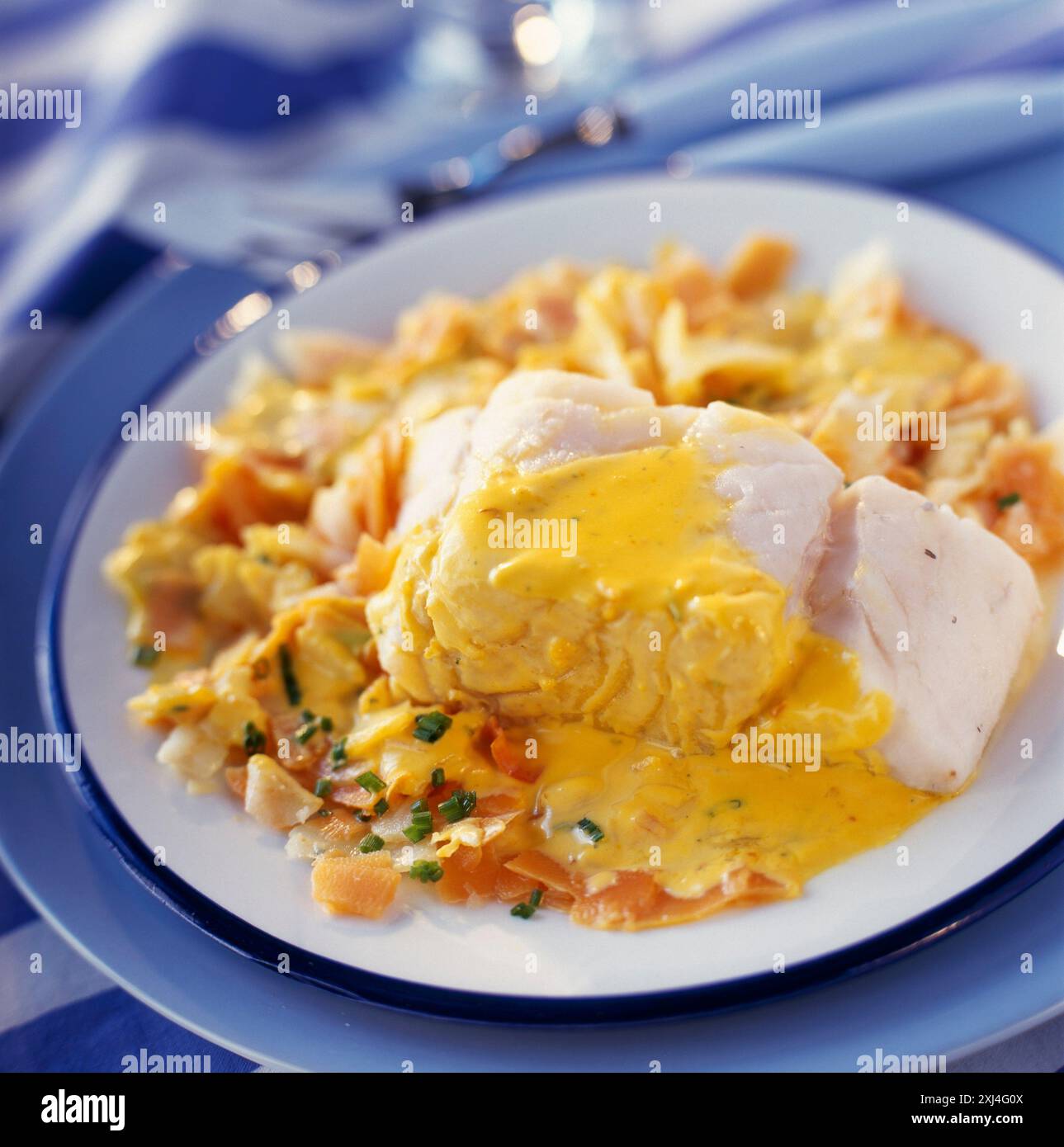 Thick piece of cod with saffron sauce and carrots Stock Photo - Alamy