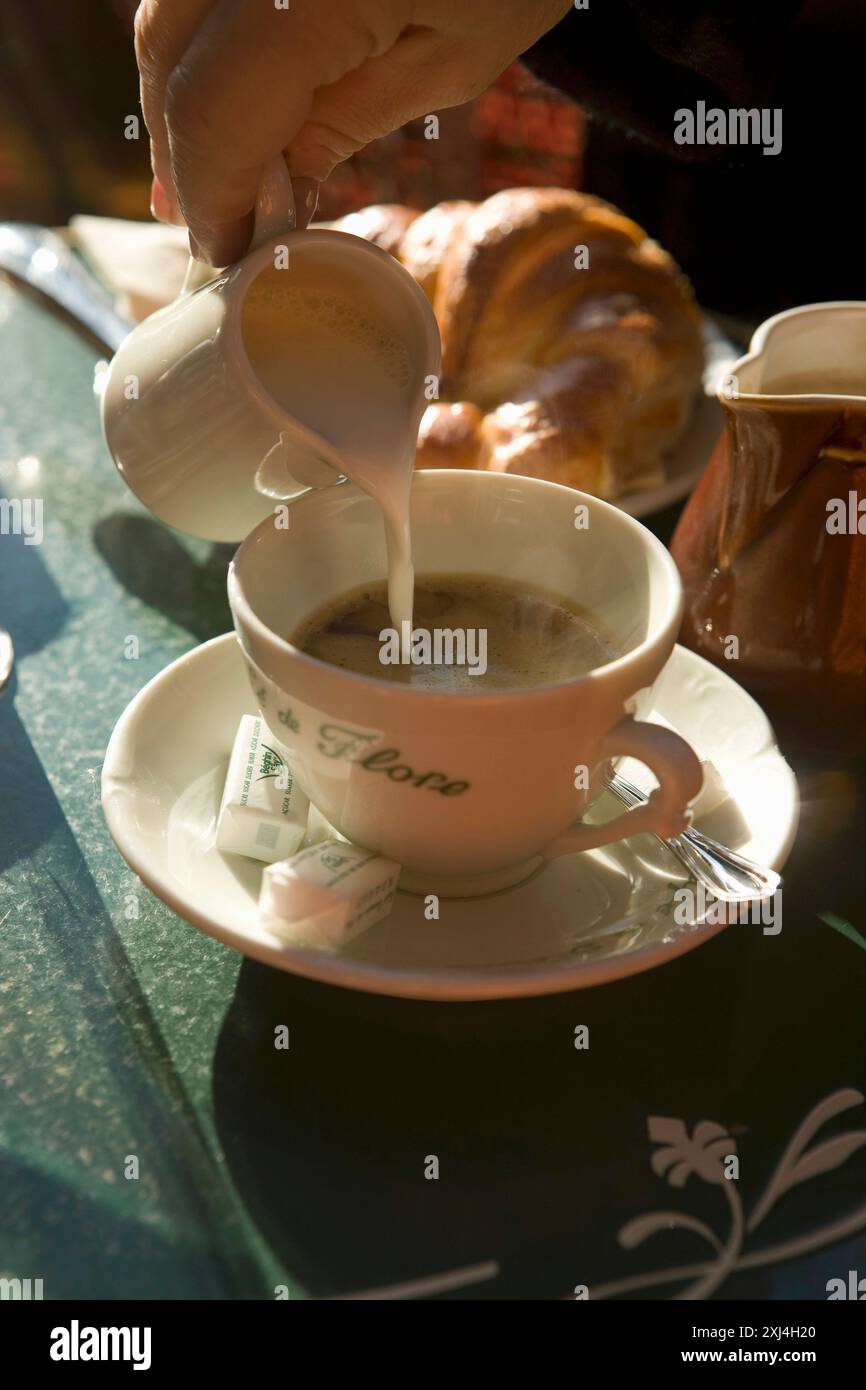 Adding milk to a cup of coffee Stock Photo - Alamy