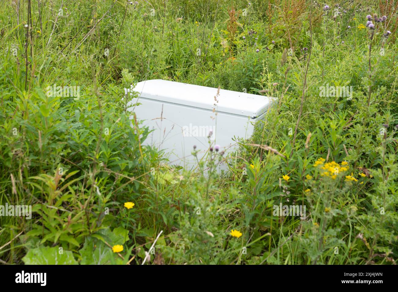 Fly tipping - Fridge freezer dumped on waste ground - UK Stock Photo ...