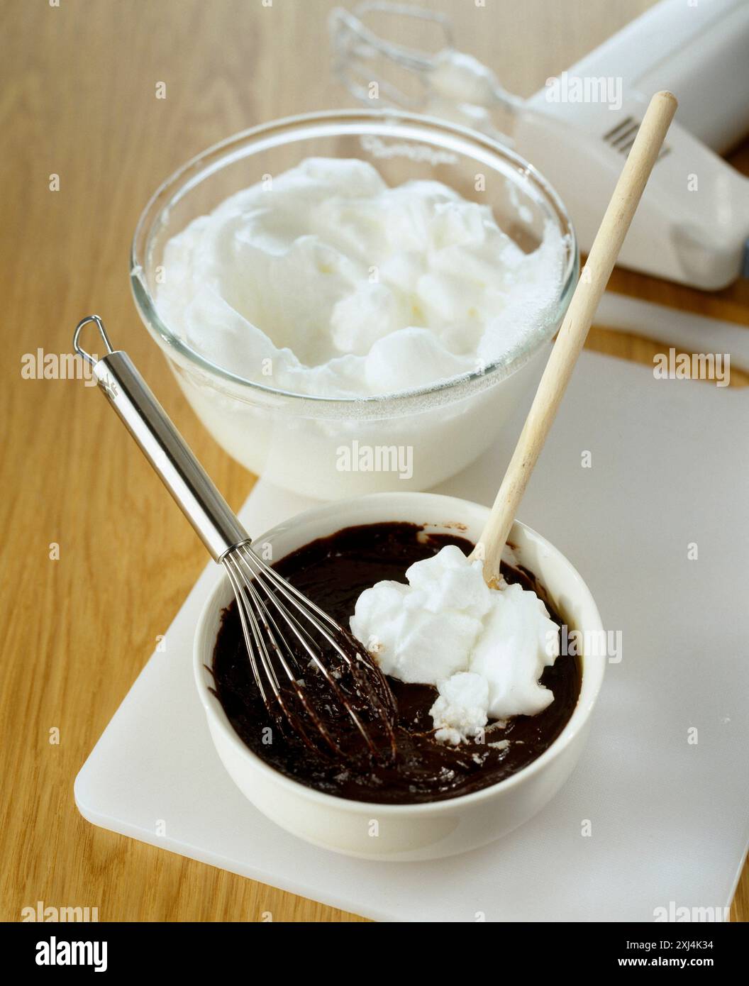 Blending the beaten egg whites to the melted chocolate Stock Photo - Alamy