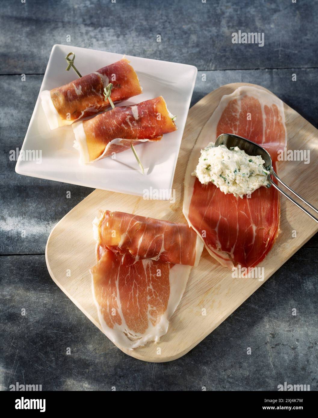 Filling the raw ham with the cheese mixture and roll Stock Photo - Alamy