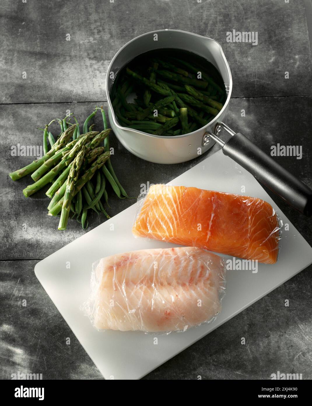 Wrapping the cod and salmon in clingfilm Stock Photo - Alamy