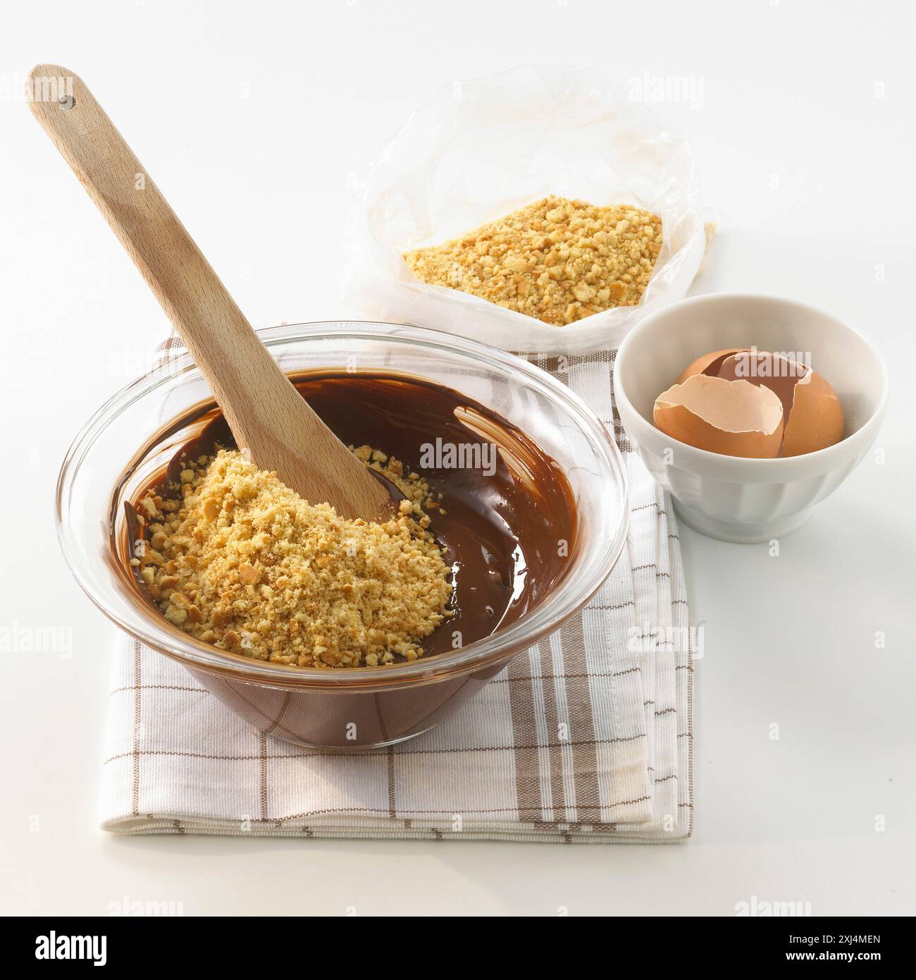Mixing together the crushed biscuits and the melted chocolate Stock ...