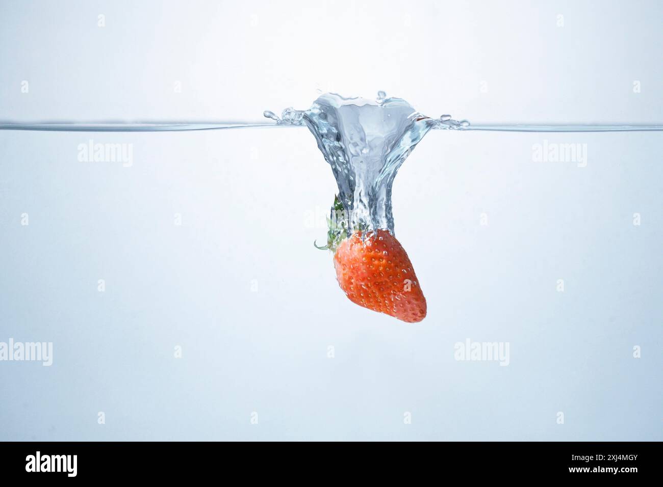 Strawberry falling in the water Stock Photo - Alamy