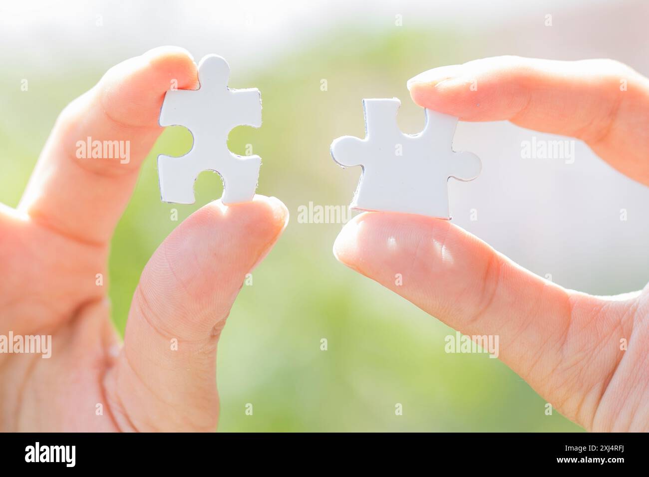 two hands trying to connect couple puzzle piece Stock Photo - Alamy