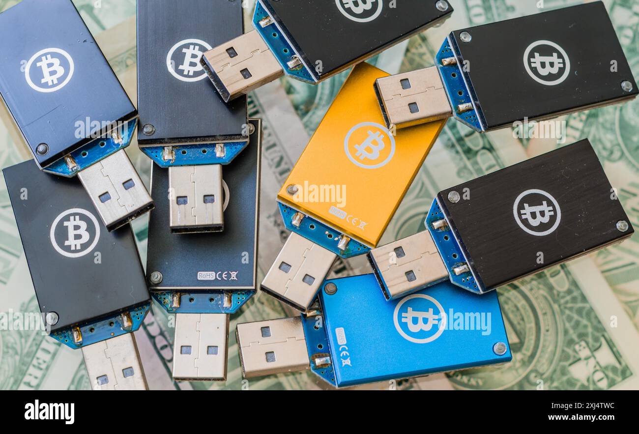 A collection of USB hardware wallets with Bitcoin logos spread over US ...