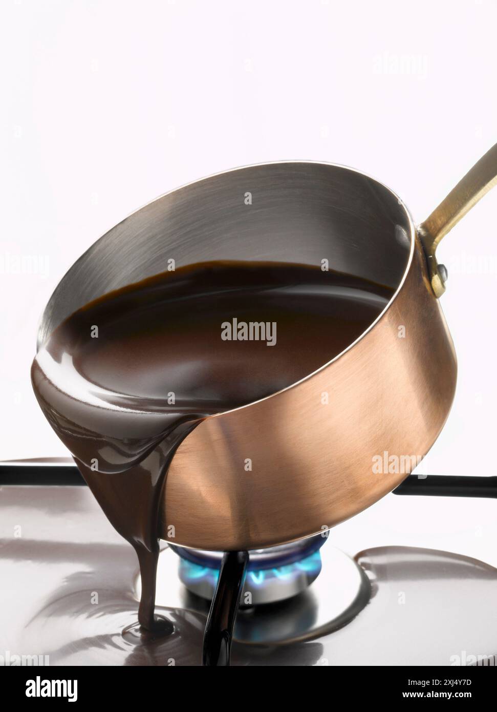Spilling the melted chocolate onto the gas cooker Stock Photo - Alamy