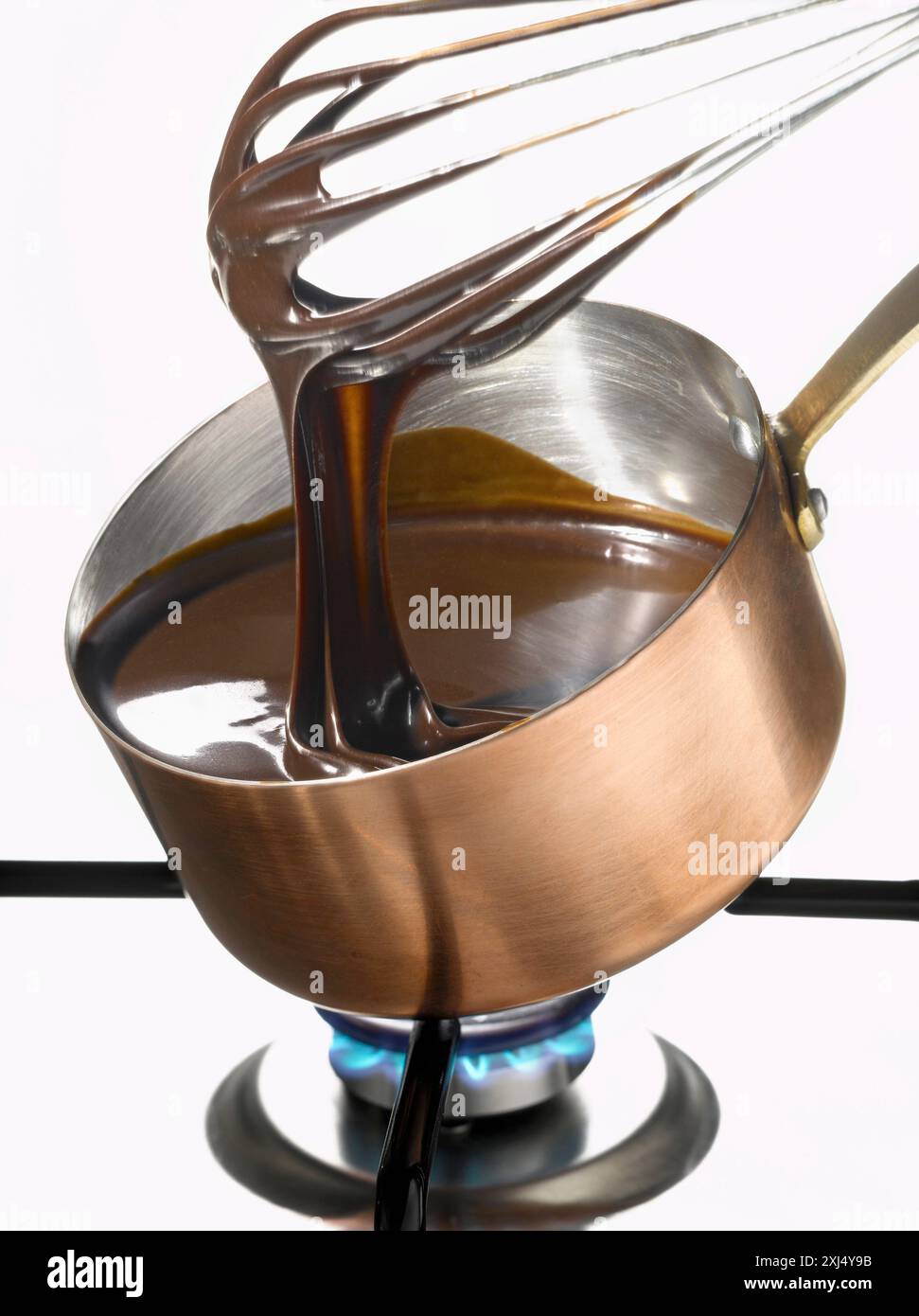 Whipping melted dark chocolate in a copper saucepan Stock Photo - Alamy