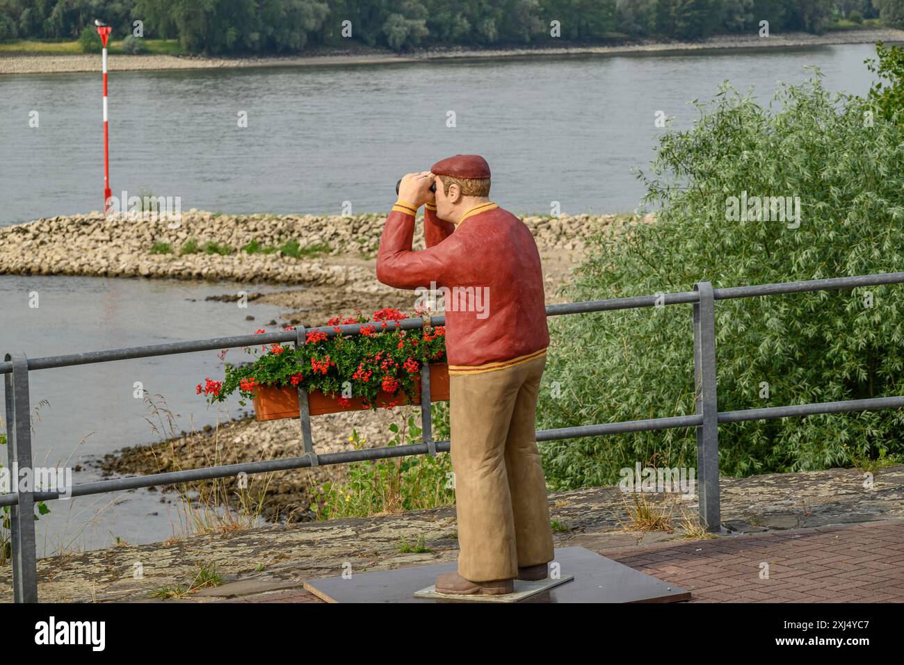 A statue looking at the river and the opposite bank with binoculars ...