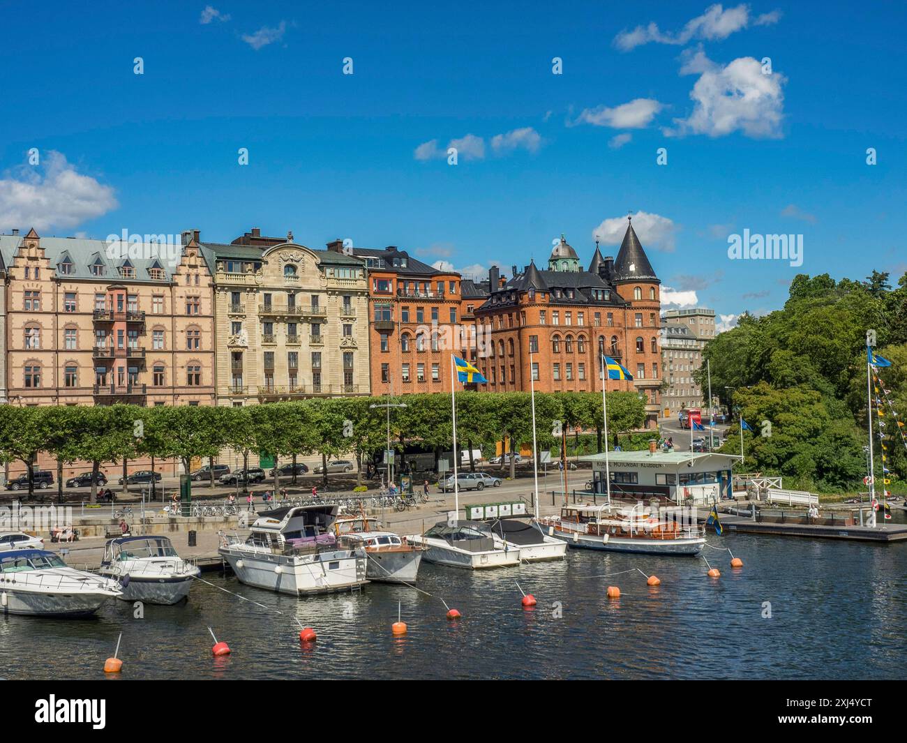 Waterfront promenade with boats and historic buildings in clear, sunny ...