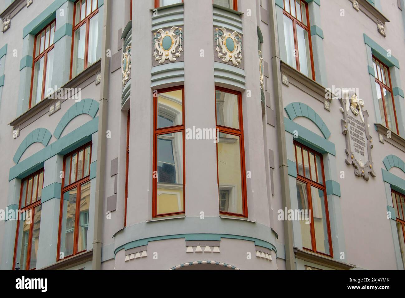 Historic building with grey facade and red window frames, decorated ...
