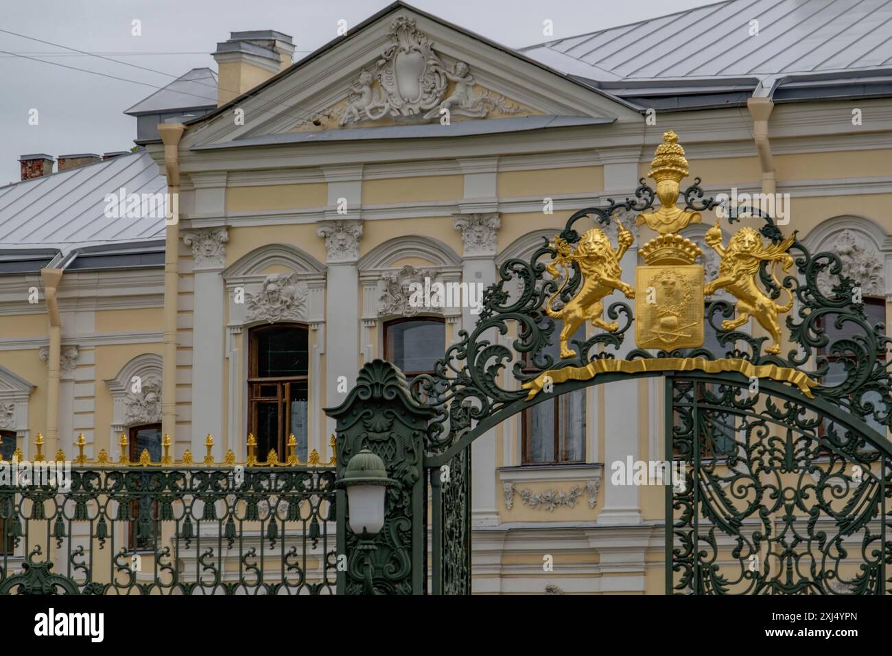 Magnificent building with baroque decorations and a wrought-iron fence with gilded details ...