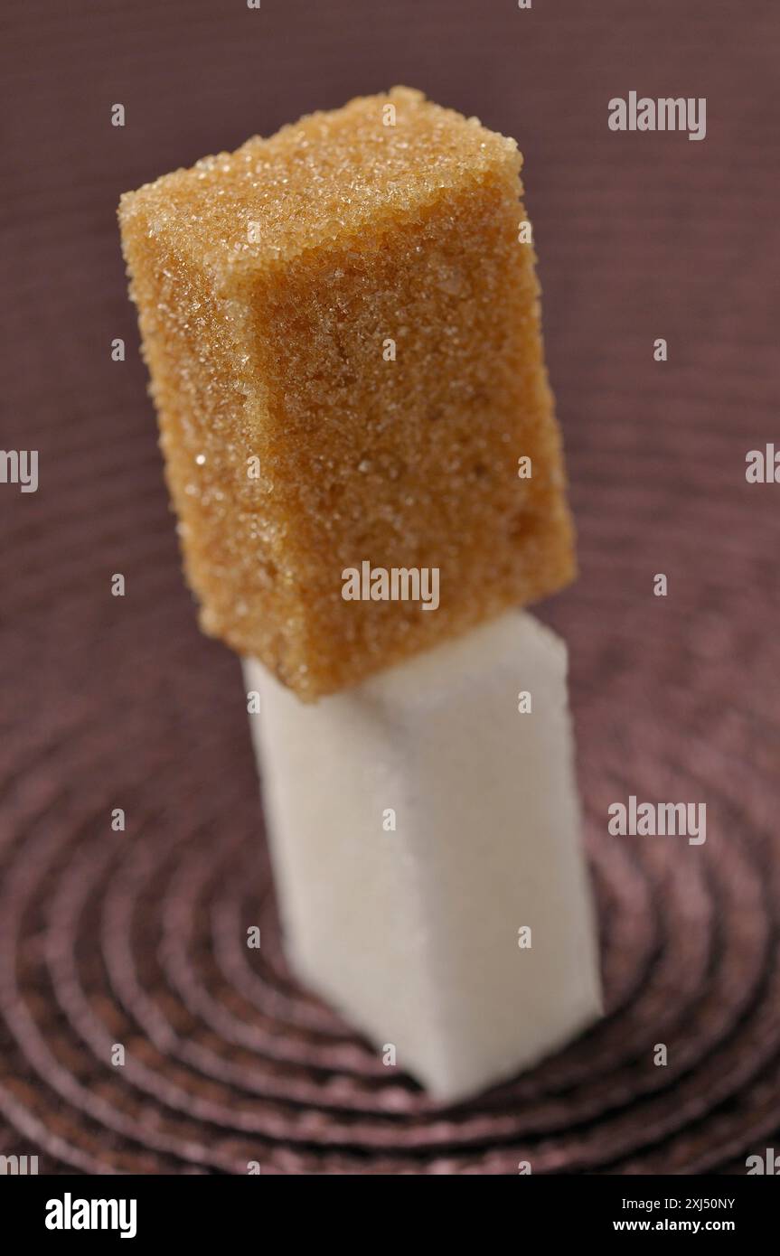 Brown sugar lump on a white sugar lump Stock Photo - Alamy