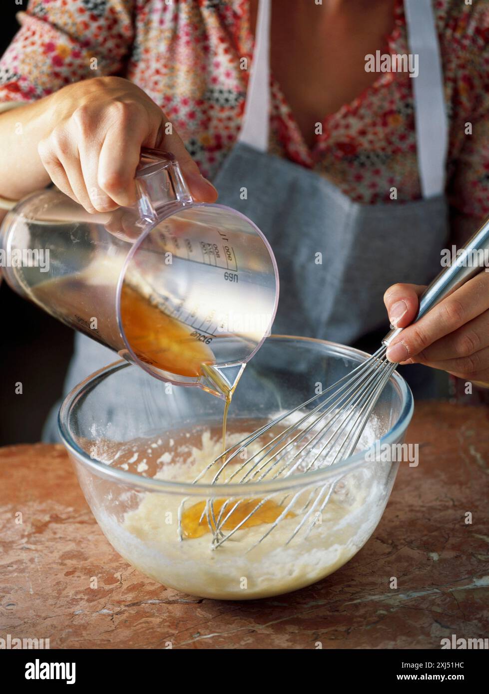 Adding the melted butter to the mixture Stock Photo - Alamy