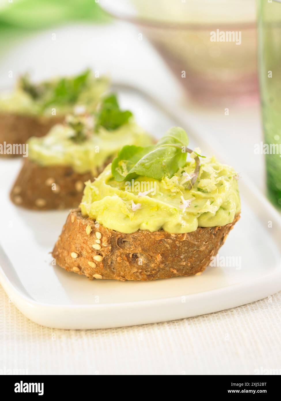Cream of avocado with herbs on a bite-size slice of bread Stock Photo ...