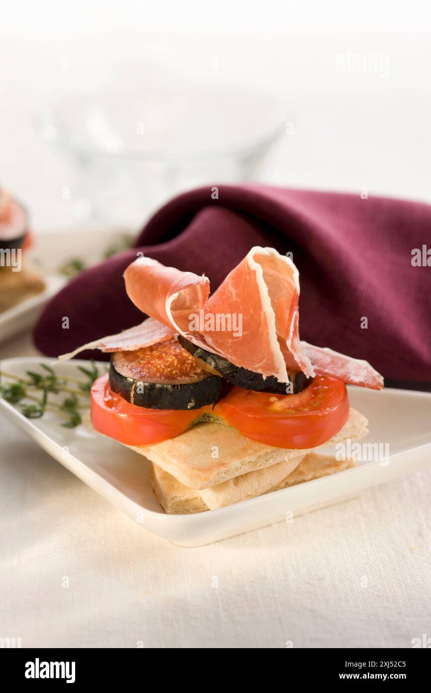 Spanish ham,fig and tomato on a bite-size slice of bread Stock Photo ...