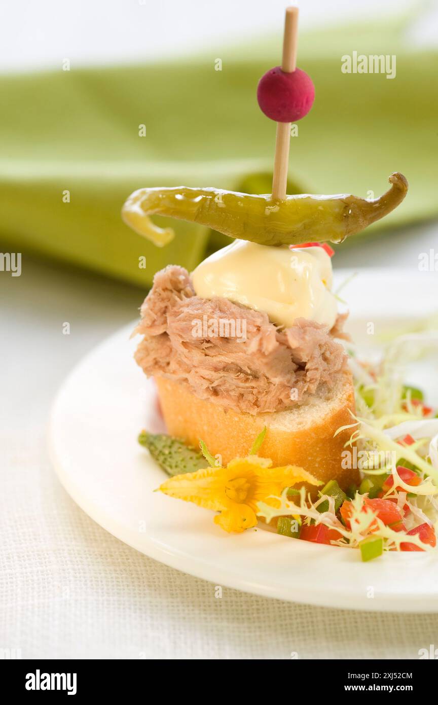 Tuna,mayonnaise and guindilla pepper on a bite-size slice of bread ...