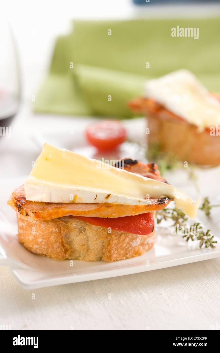 Pork backbone,red pepper and Brie on a bite-size slice of bread Stock ...