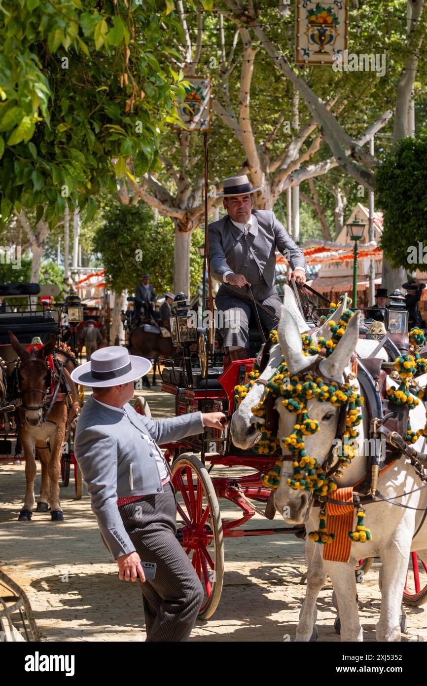 Men in hats and traditional attire driving a decorated horse-drawn ...
