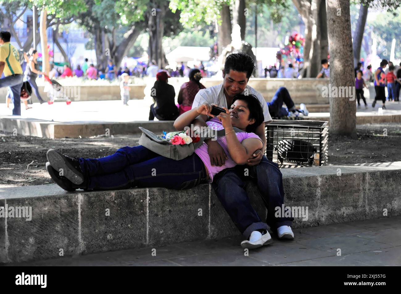 Oaxaca, Mexico, Central America, A couple is sitting in a park, the man ...
