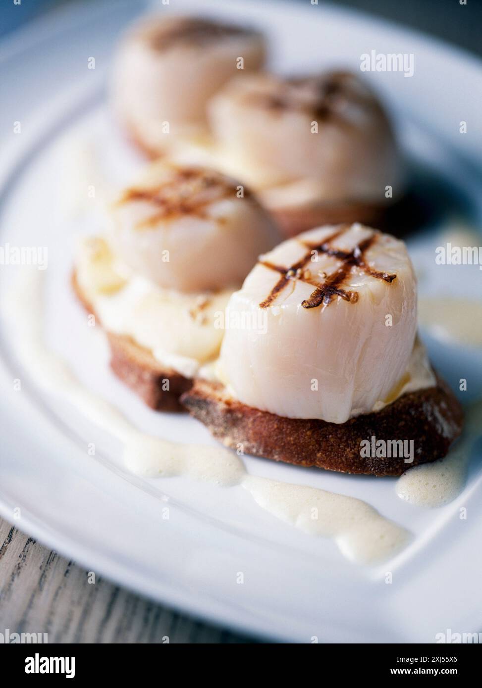 Scallops on toast with white butter sauce Stock Photo - Alamy