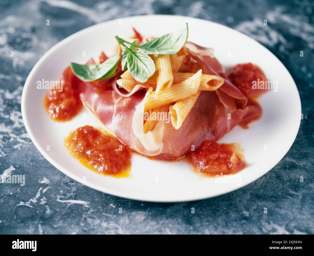 Raw ham purse filled with penne in tomato sauce and topped with basil ...