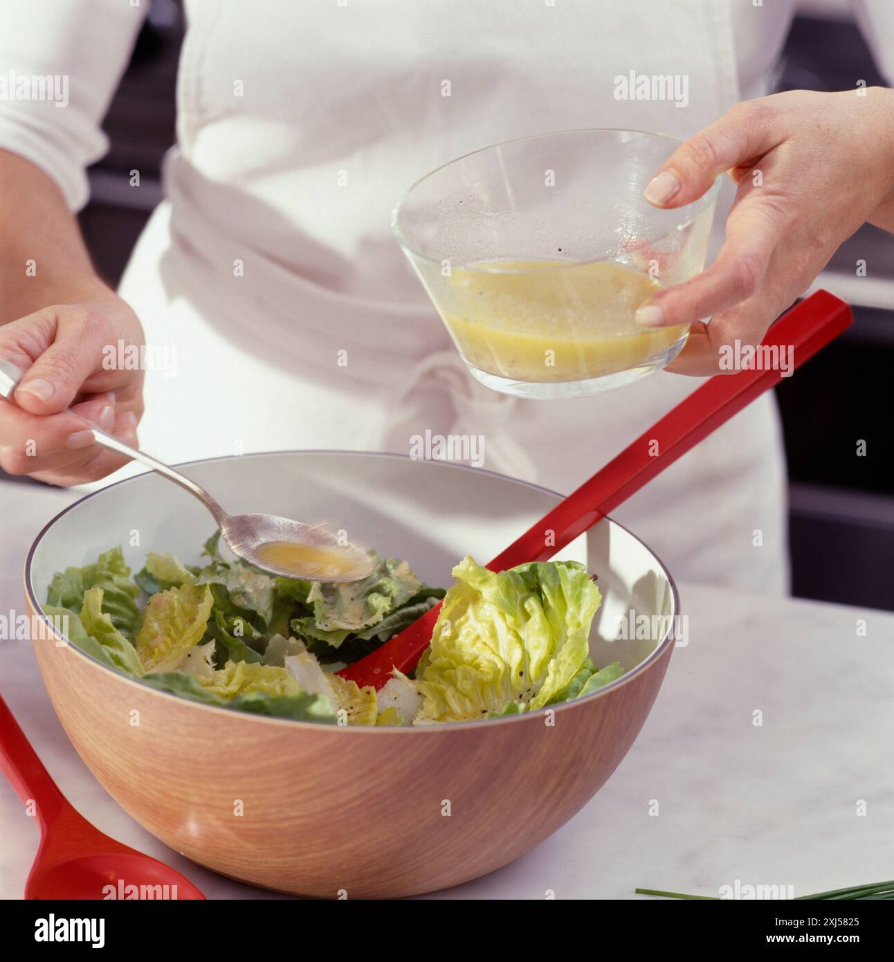Adding the french dressing to the salad Stock Photo - Alamy