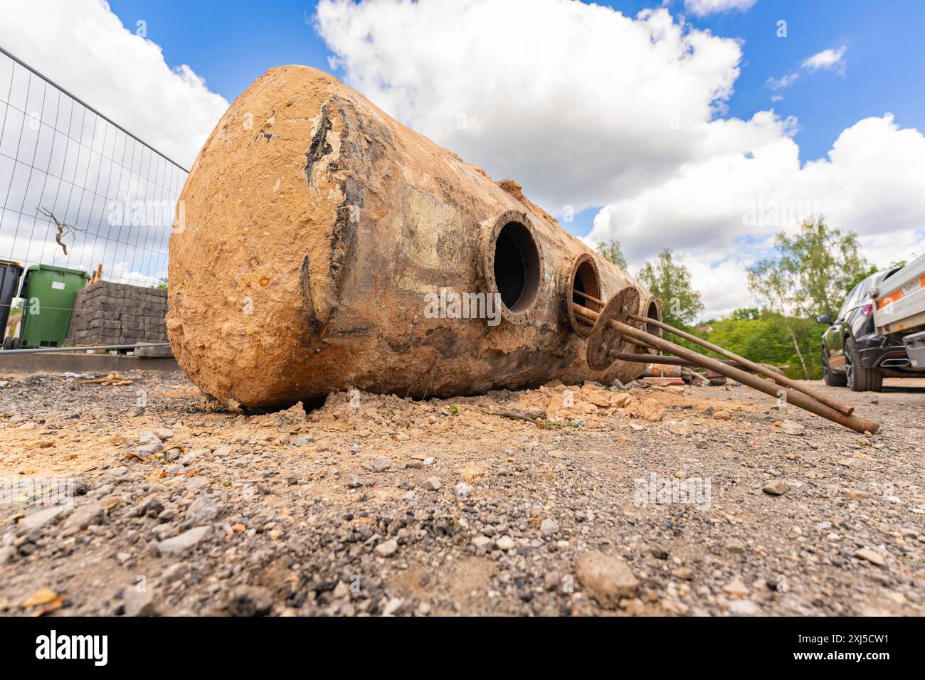 An old, rusty tank lies on a construction site surrounded by sand and ...