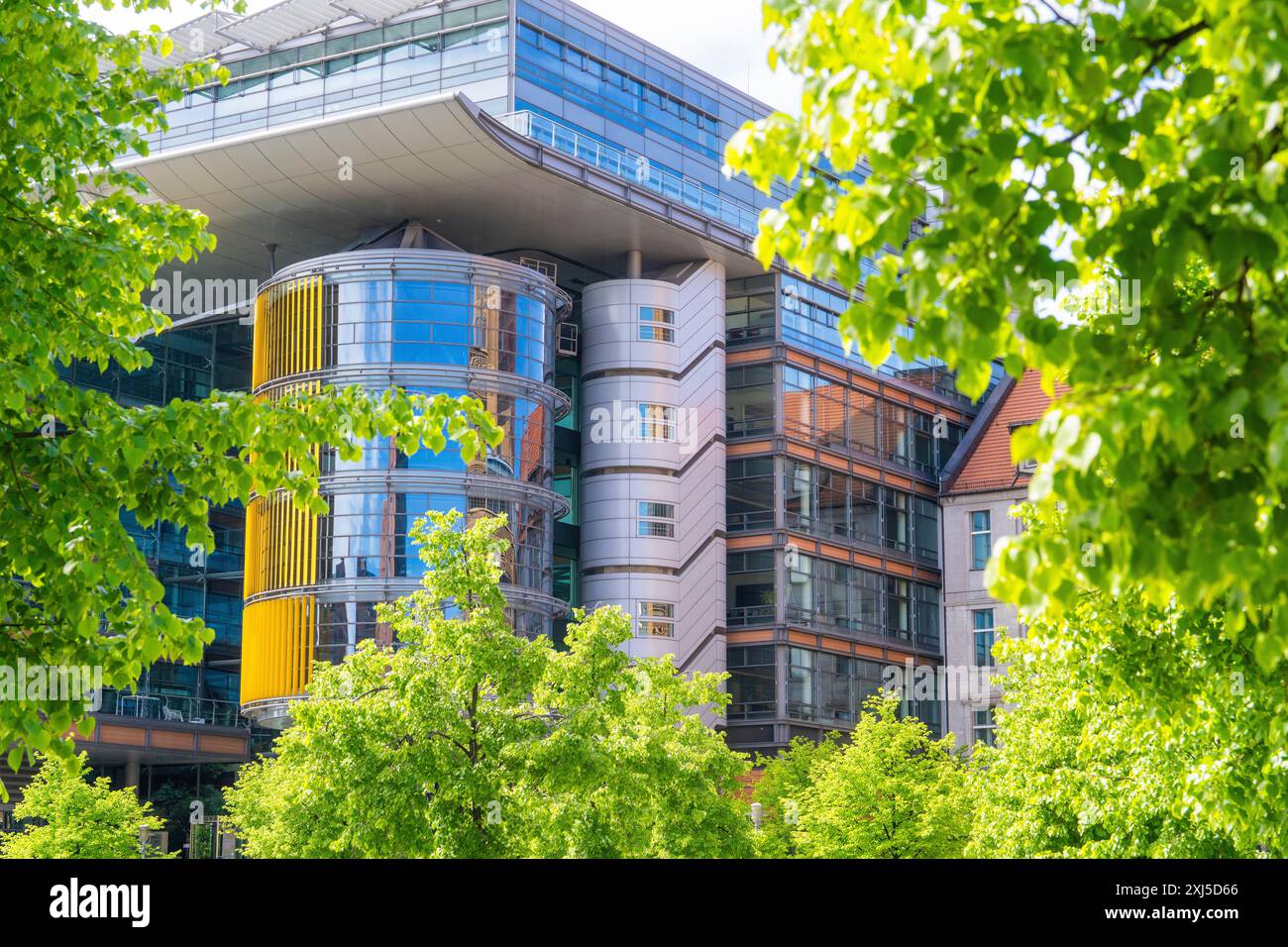 Modern, urban building with glass facades, embedded in lush greenery ...