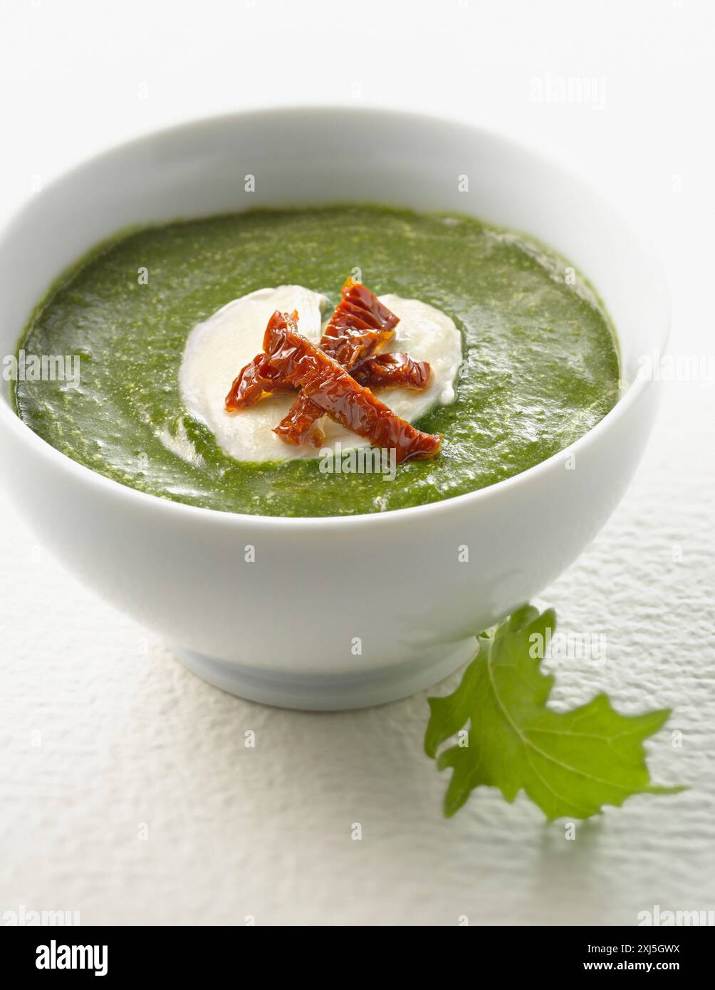 Cream of rocket soup with mozzarella and sun-dried tomatoes Stock Photo ...