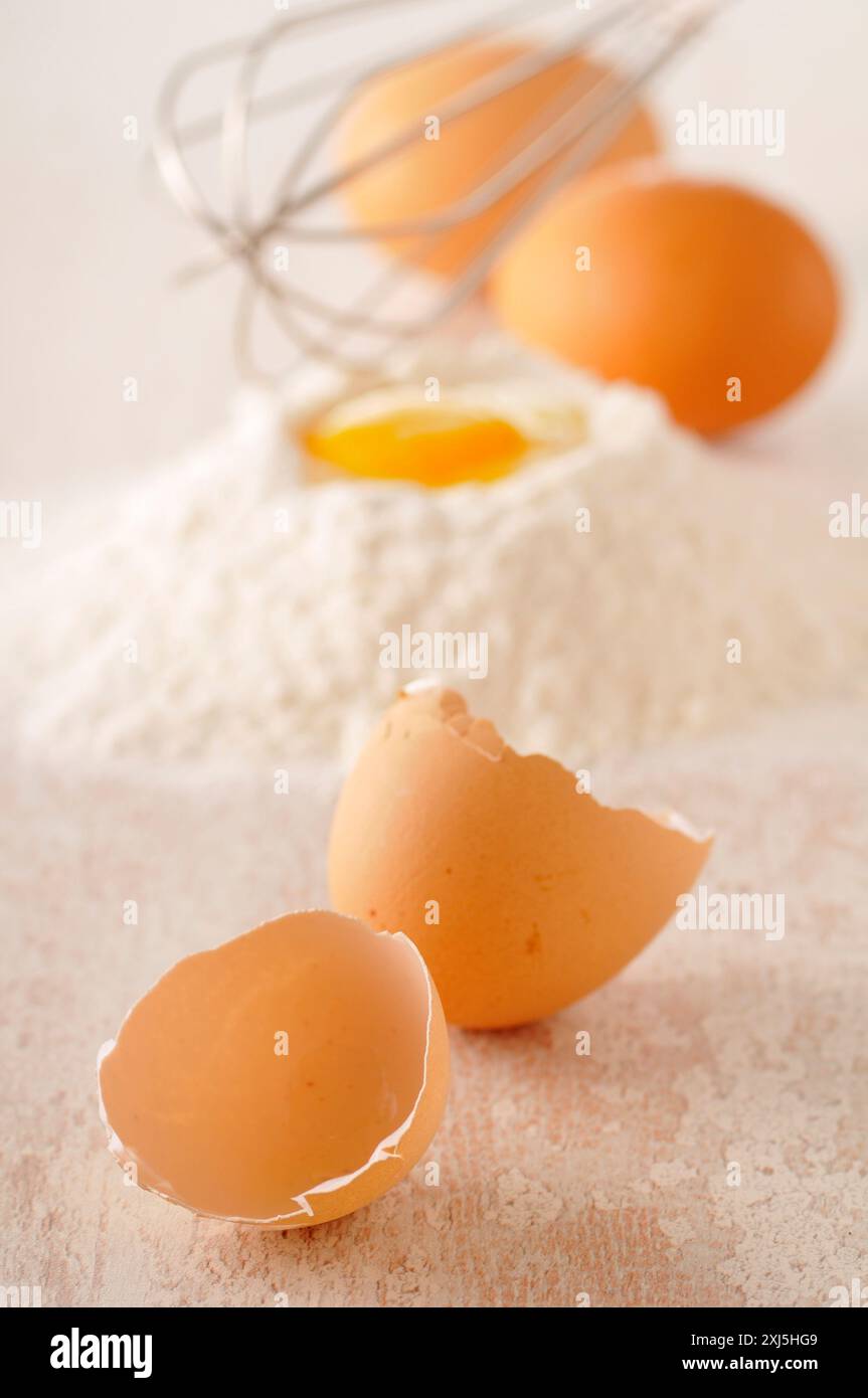 Broken egg,flour and whisk Stock Photo - Alamy