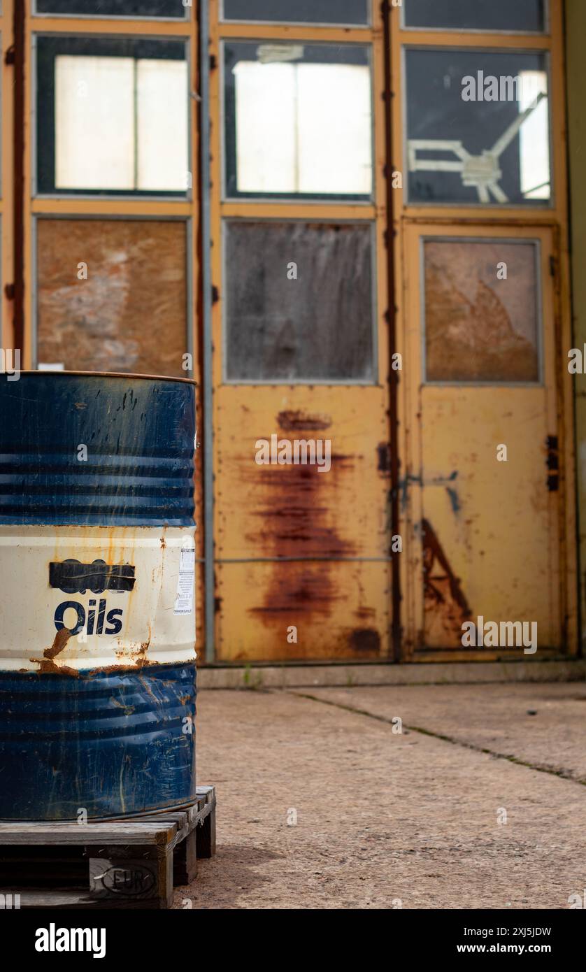 Rusty old oil drum in an abandoned junkyard. Industrial retro feeling ...
