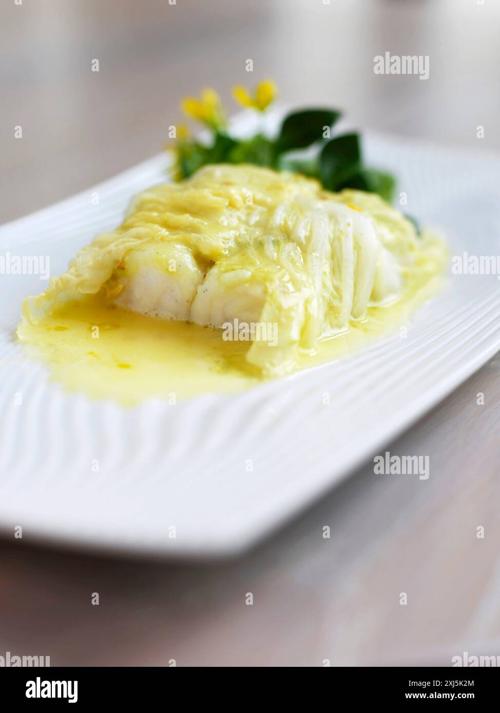Piece of cod with butter sauce Stock Photo - Alamy