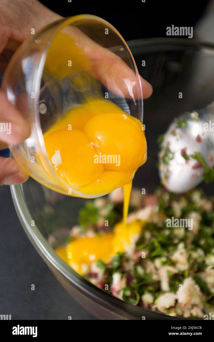 Adding the egg yolks to the mixture Stock Photo - Alamy