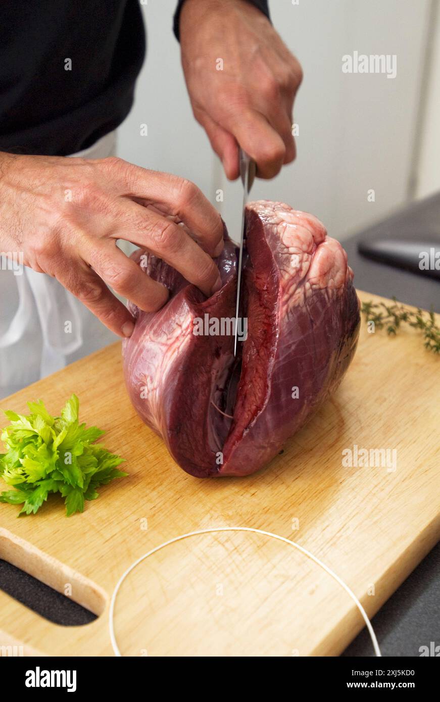 Cutting the raw heart in half Stock Photo - Alamy