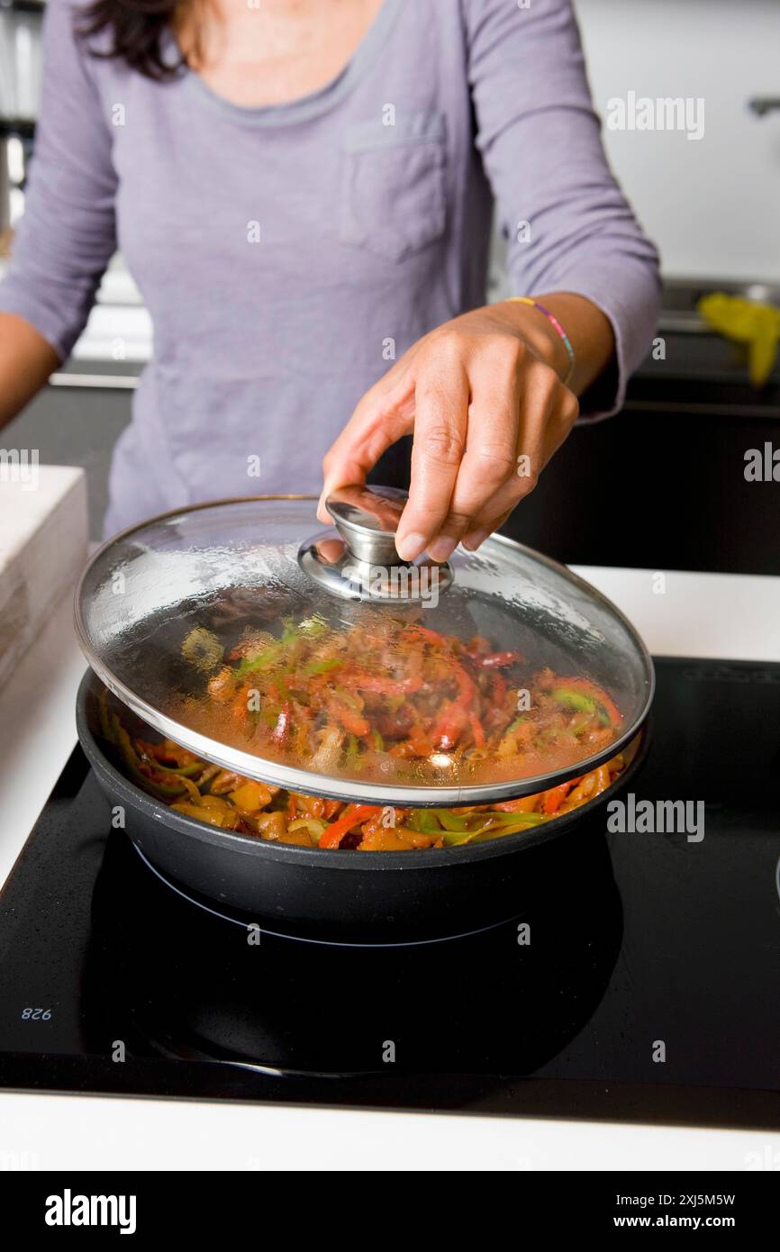 Covering the frying pan and leave to simmer Stock Photo - Alamy